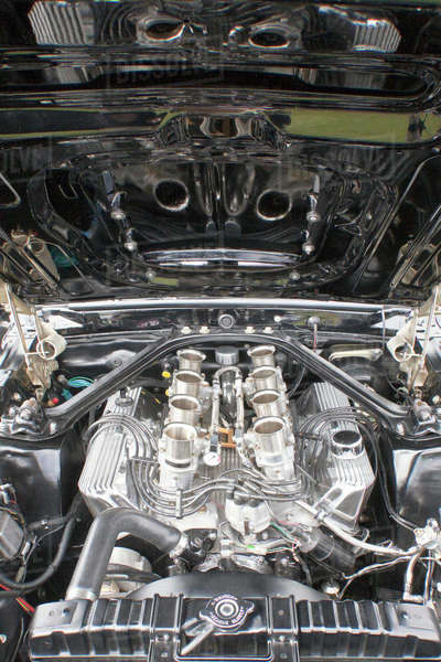 Racing car engine under the open hood - Stock Photo - Dissolve