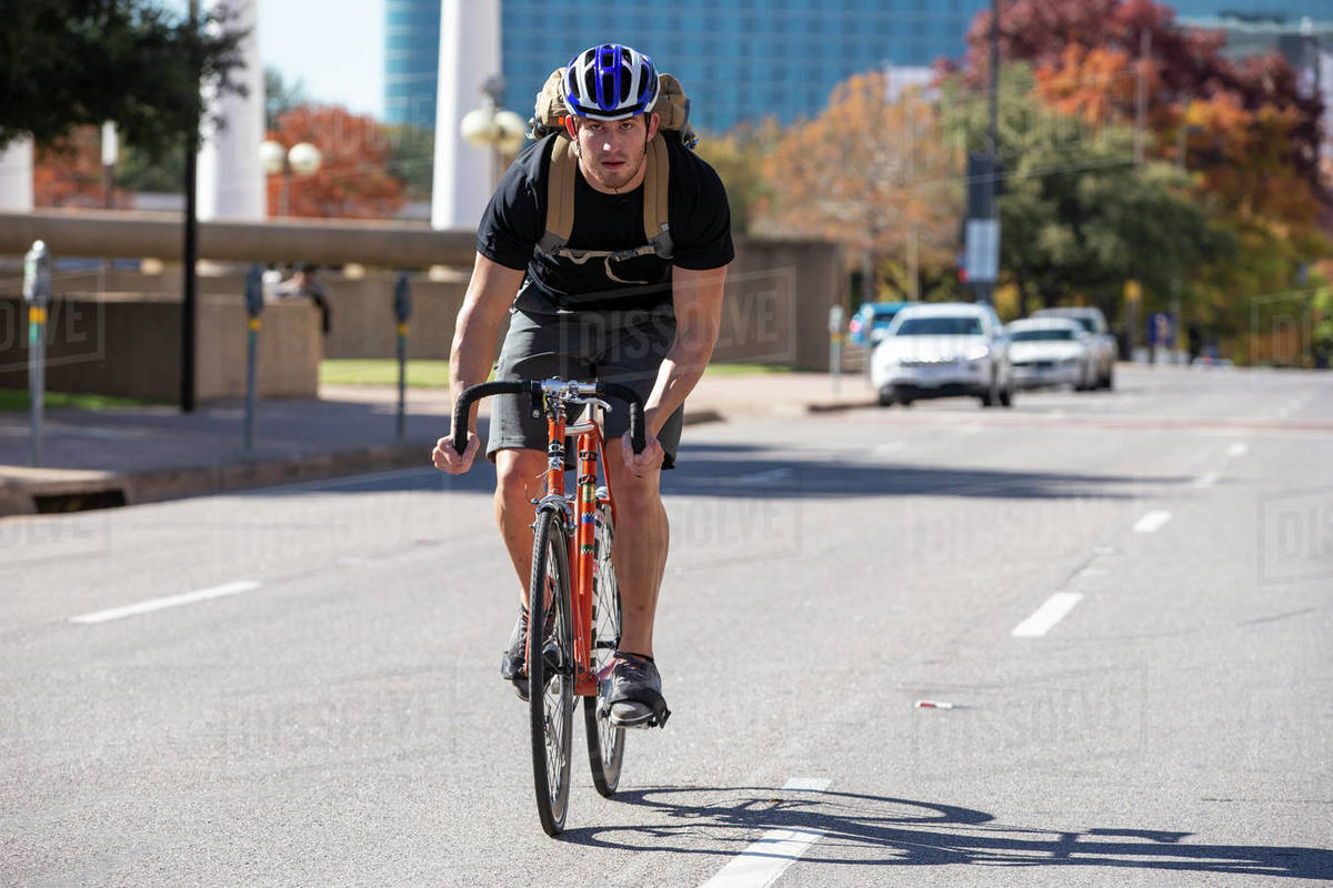Happy man riding bicycle on sunny city street - Royalty-free Stock ...
