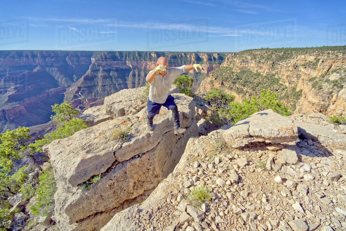 A man jumping across a cliff crevice east of Shoshone Point at Grand ...