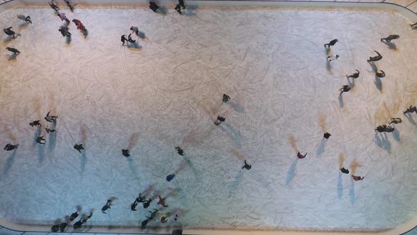 People are Skating on Illuminated Ice Rink in the Evening. Aerial ...