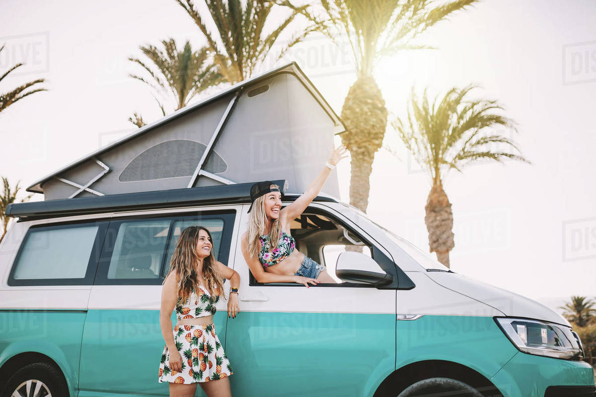 Two young women having fun in her van near the beach - Stock Photo ...