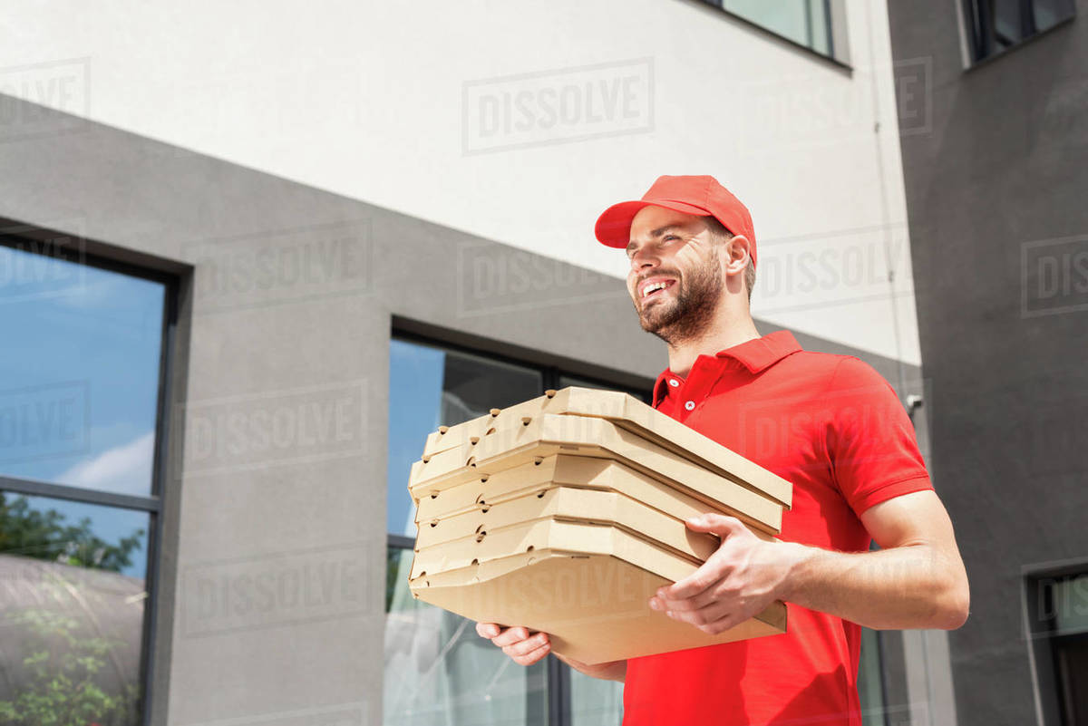 low angle view of caucasian delivery man carrying pizza boxes - Royalty ...