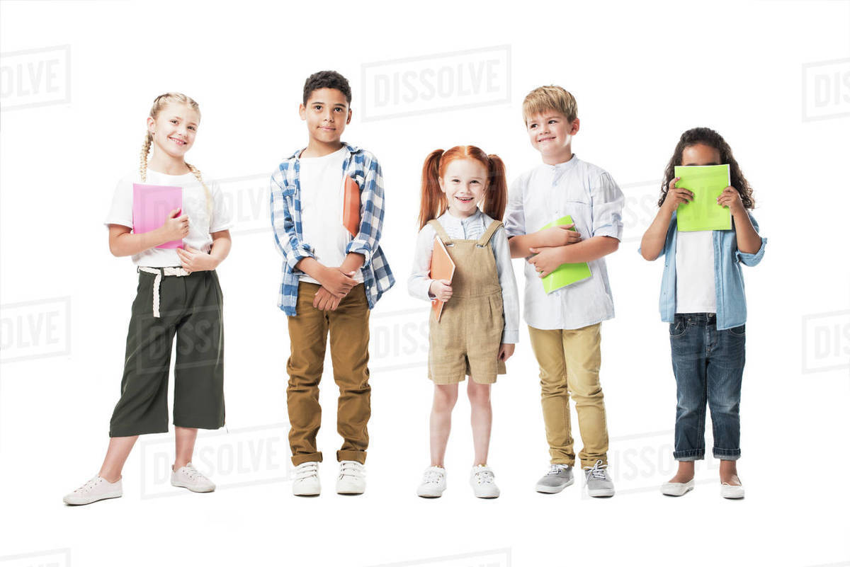 Adorable multiethnic children holding textbooks and smiling at camera ...