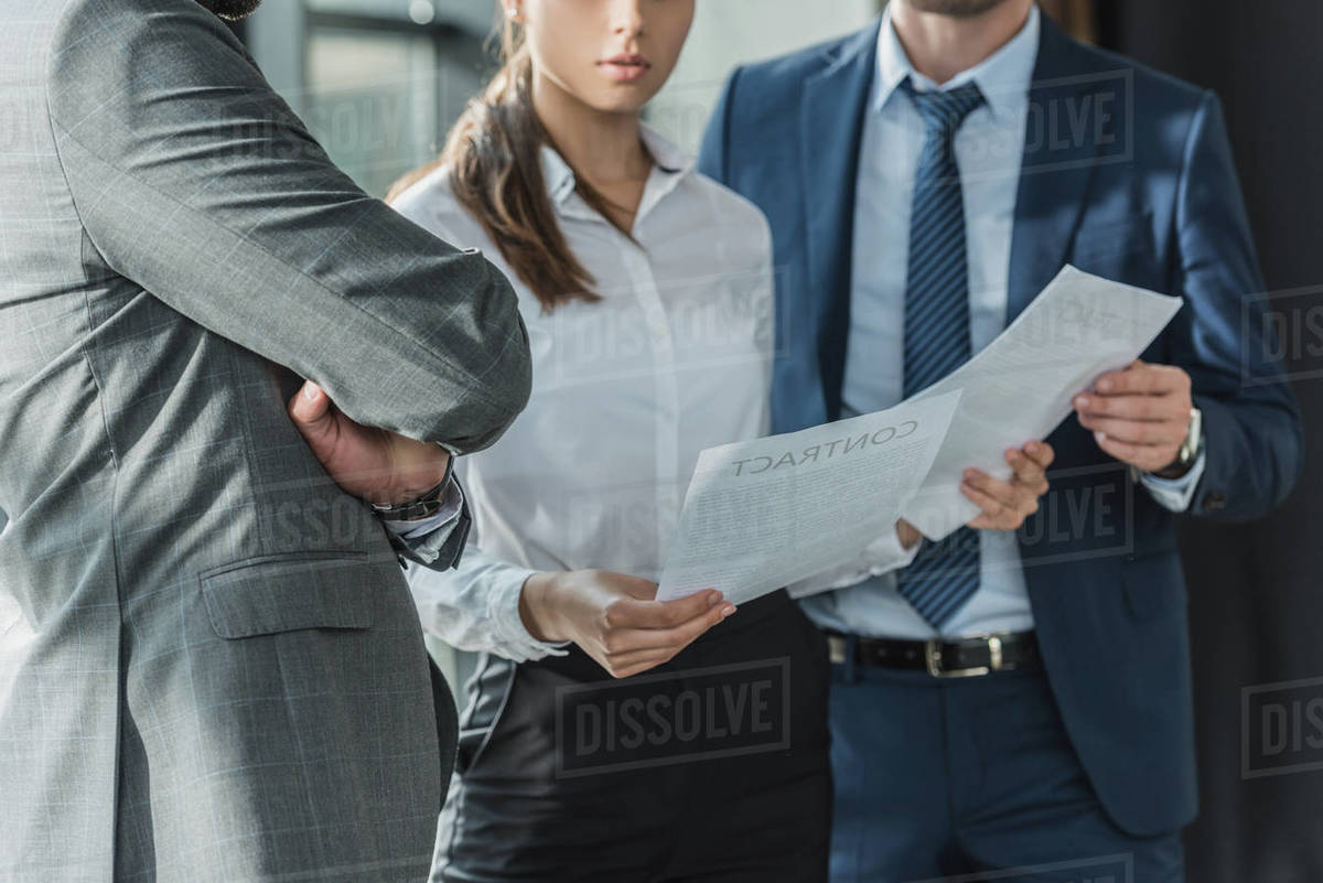 Cropped shot of business people discussing documents together at office ...