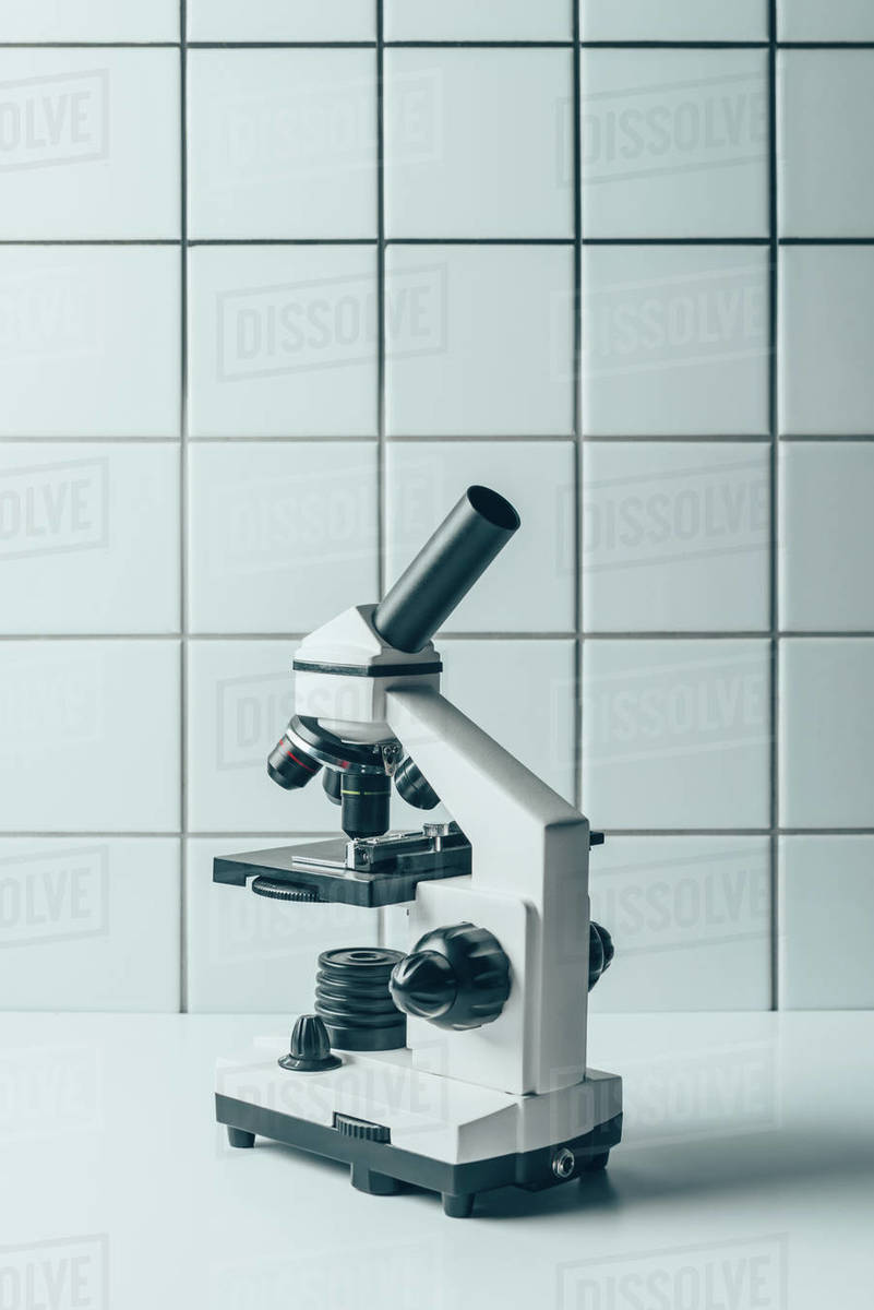 Optical microscope on white tablet in front of tiled wall - Royalty ...