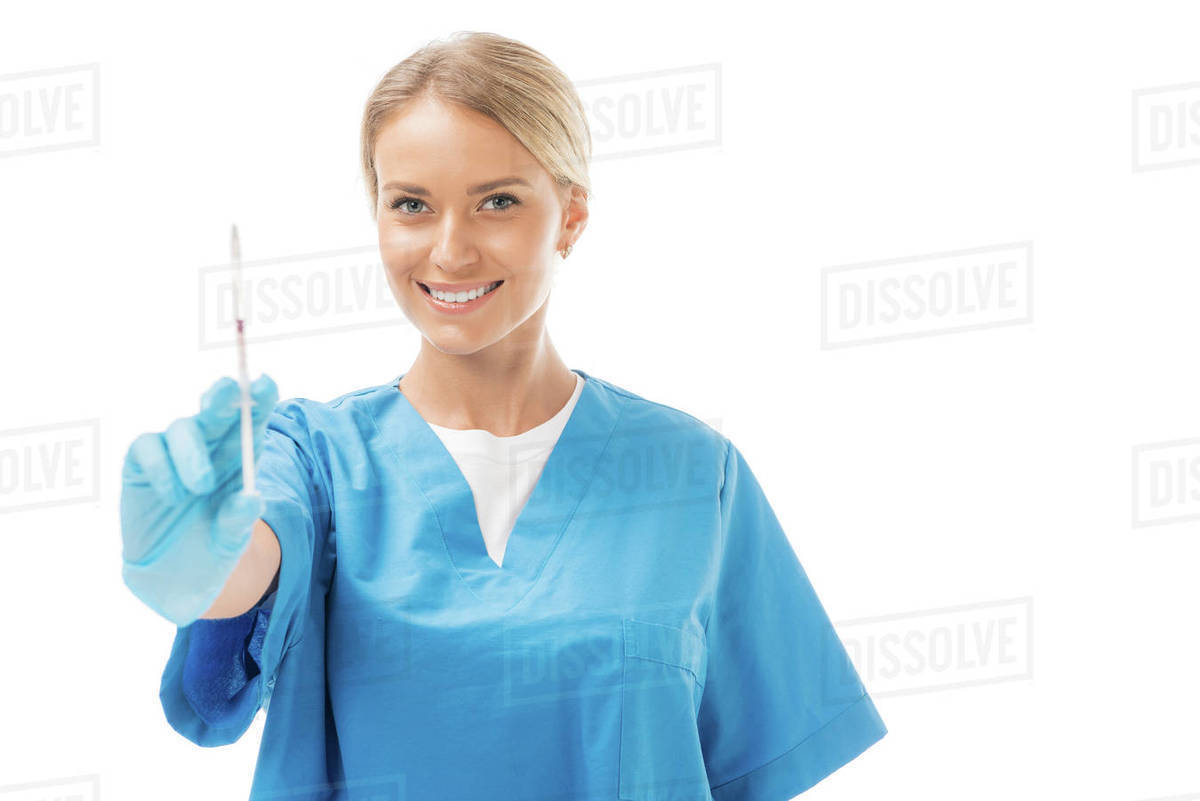 happy young nurse holding syringe for injection and looking at camera ...