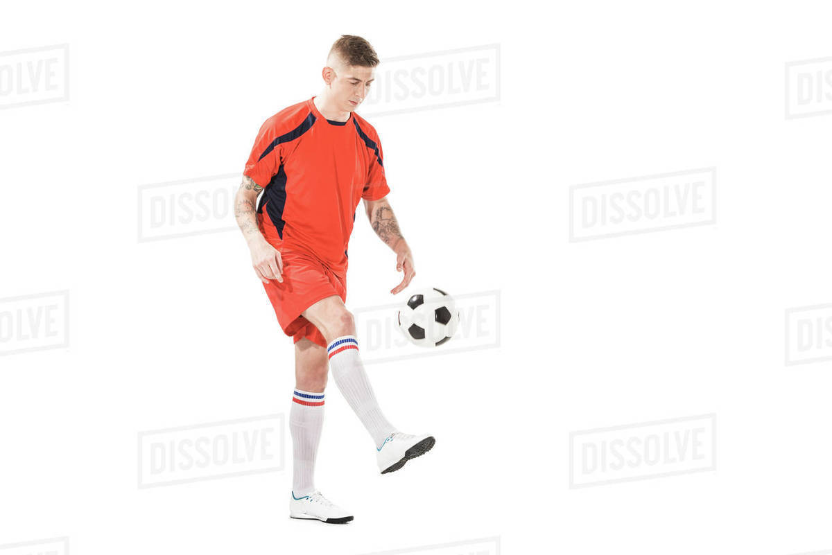 full length view of handsome young sportsman playing with soccer ball ...