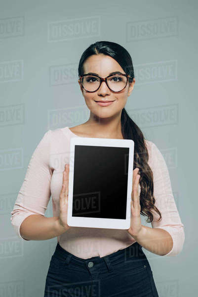 woman showing digital tablet with blank screen, isolated on grey ...