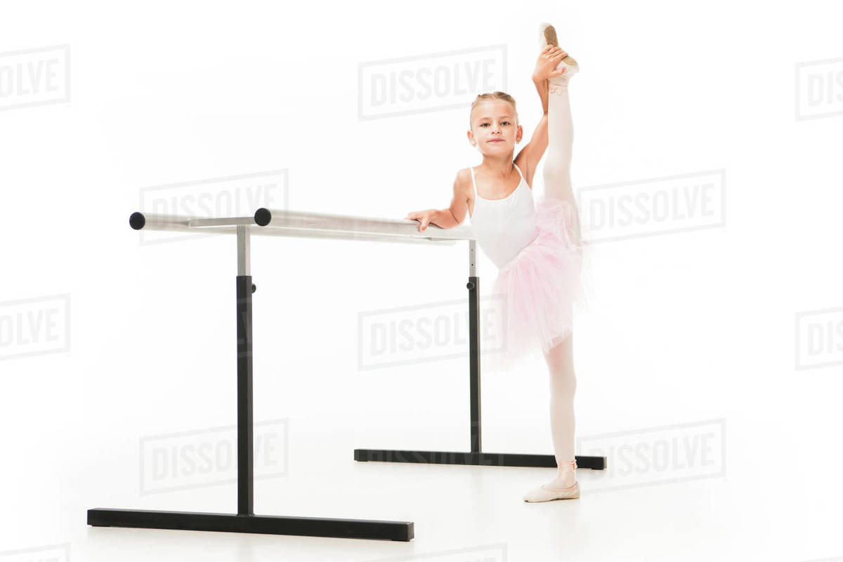 Beautiful little ballerina in tutu and pointe shoes stretching at ...