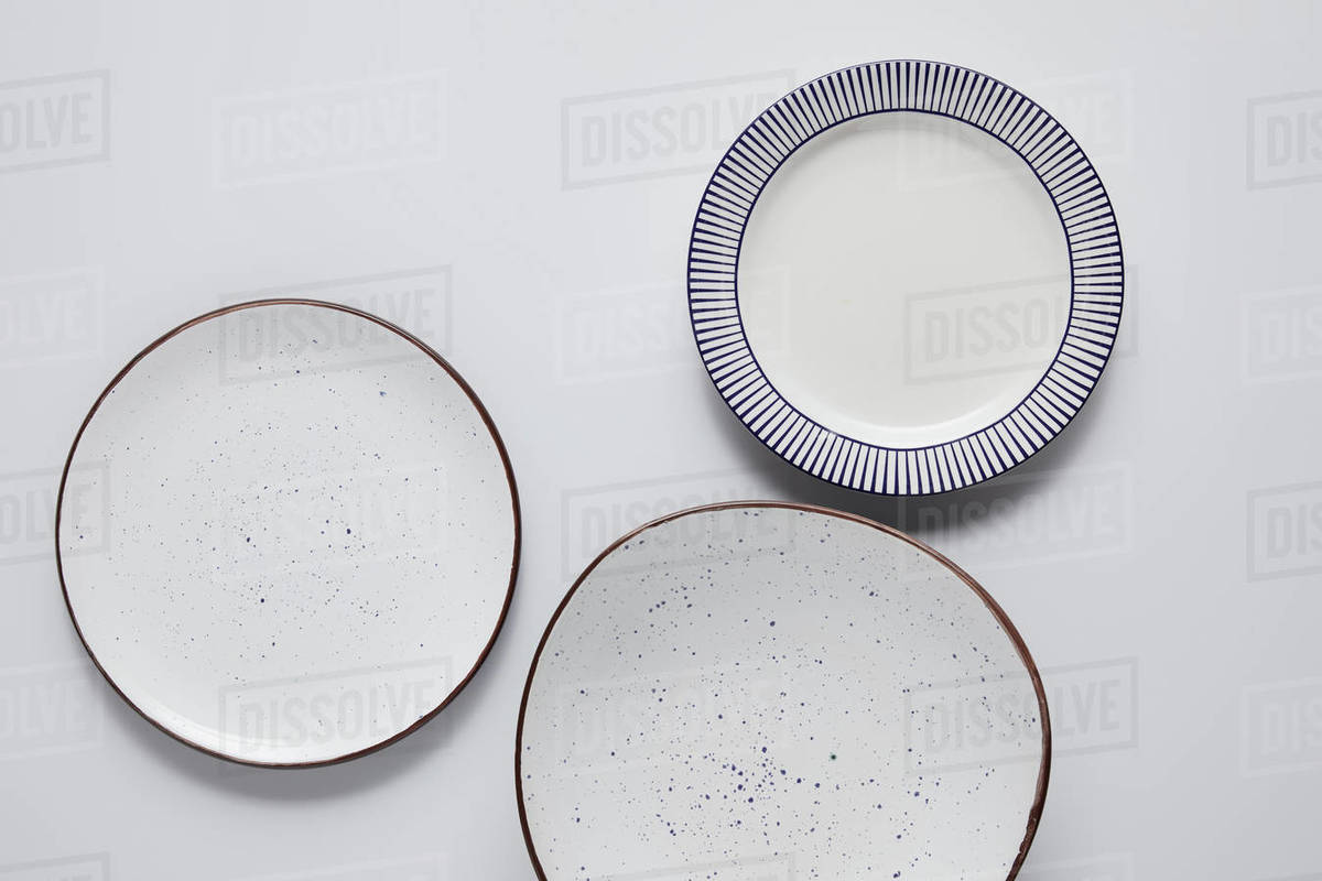 Top view of three different ceramic plates on white table, minimalistic ...