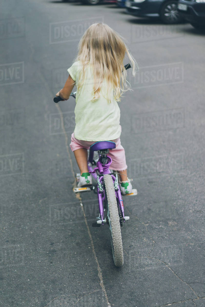 Back view of cute kid riding bicycle on street - Royalty-free Stock ...