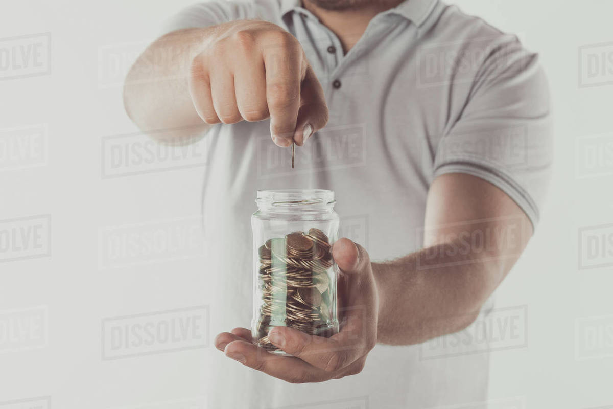 Cropped image of man putting coin into jar isolated on white, saving ...