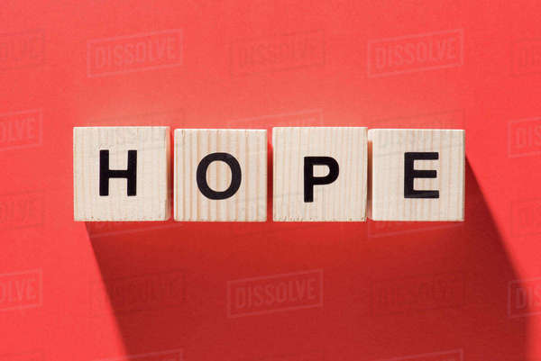 Top view of lettering hope from wooden cubes on red background ...