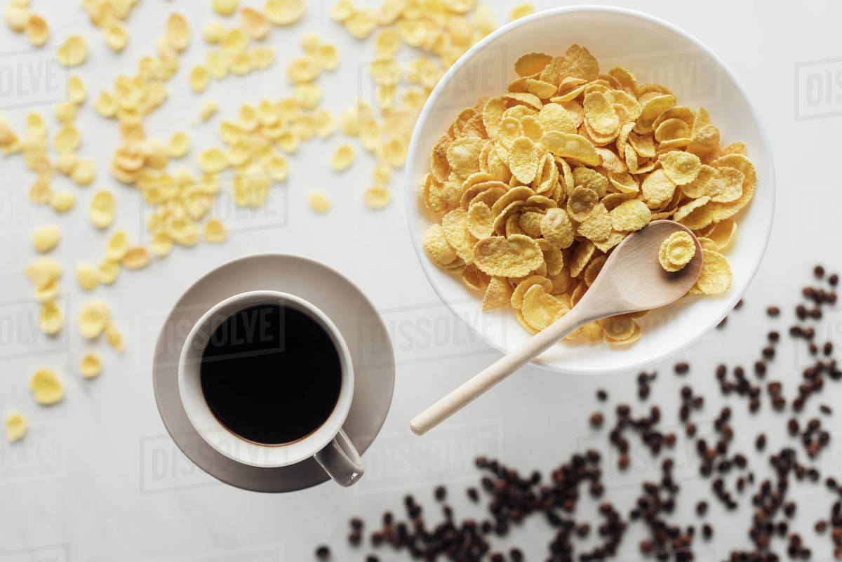 top view of bowl of dry cereal breakfast with cup of coffee on white ...