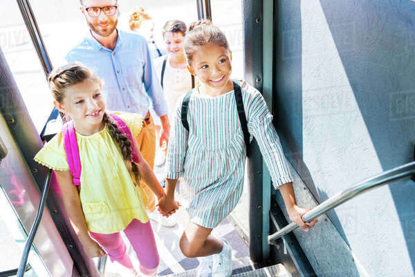 group of pupils entering school bus with teacher - Royalty-free Stock ...