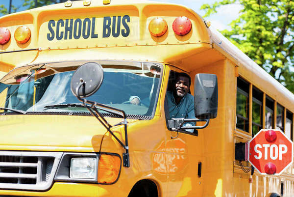 handsome senior school bus driver looking at camera through window ...