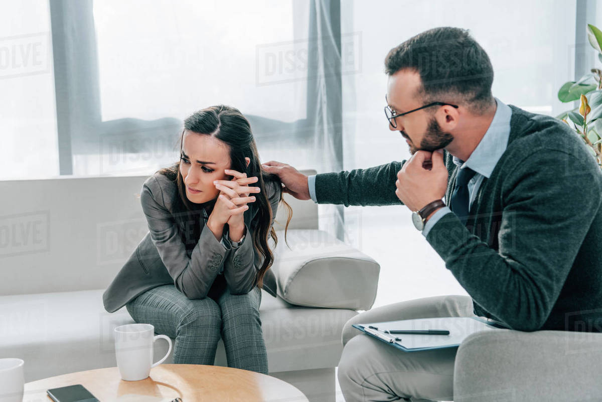 psychologist touching shoulder of crying patient in doctors office ...