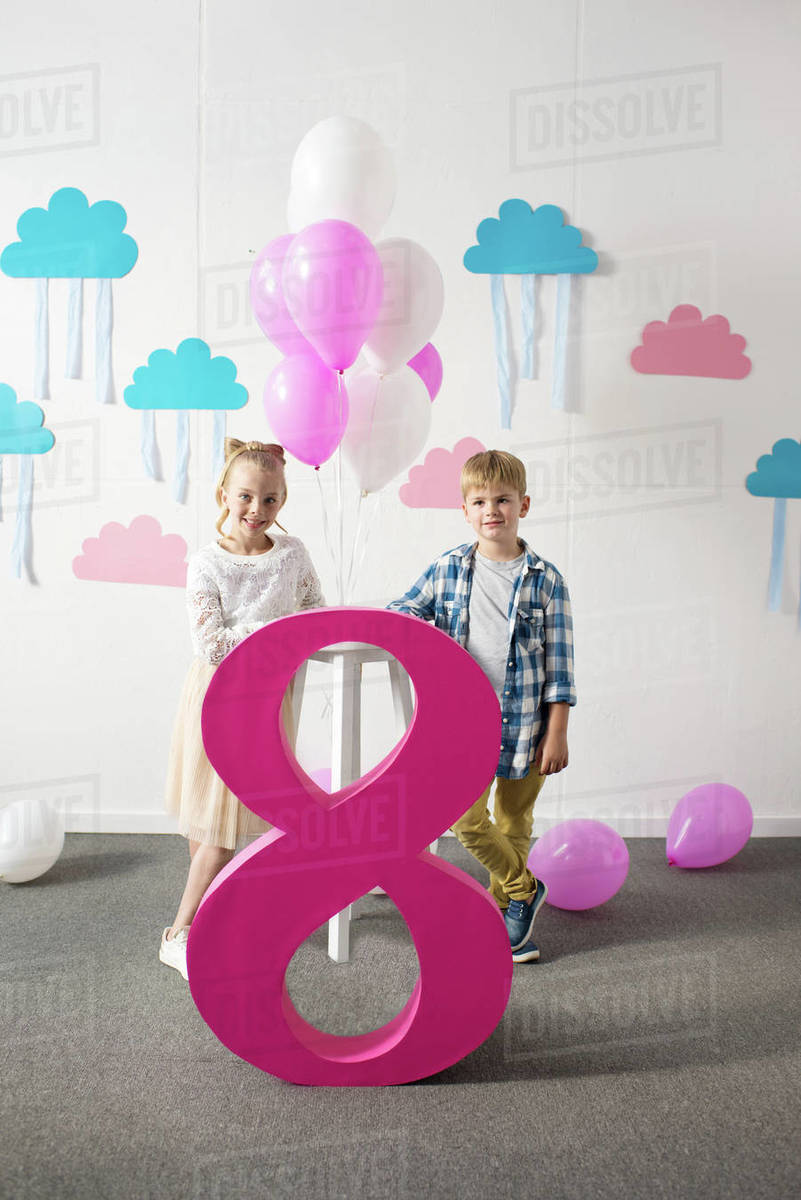 adorable happy kids posing with decorative pink number eight at ...