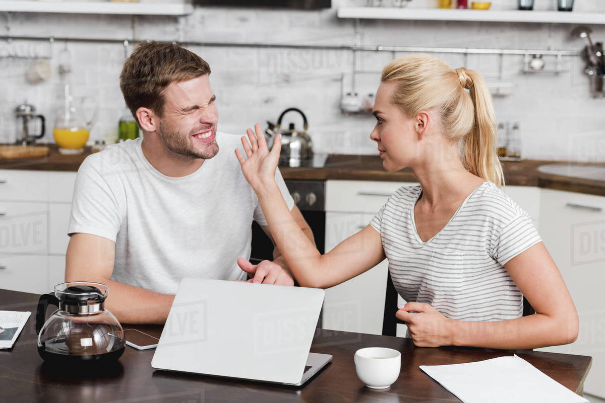 emotional young woman slapping boyfriend during quarrel at home ...