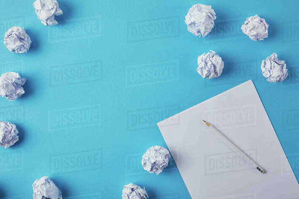 top view of crumpled papers with blank paper and pencil on blue surface ...
