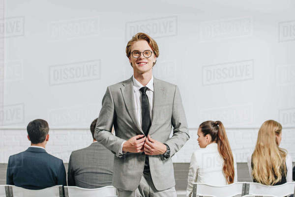 cheerful handsome coach looking at camera during business training in ...