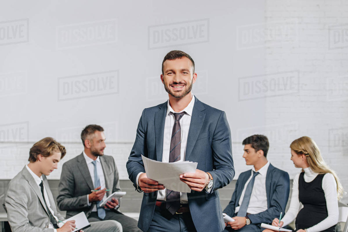 happy business coach standing in front of businesspeople at training in ...