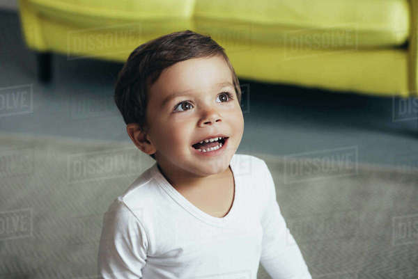 Portrait of adorable excited child at home - Stock Photo - Dissolve