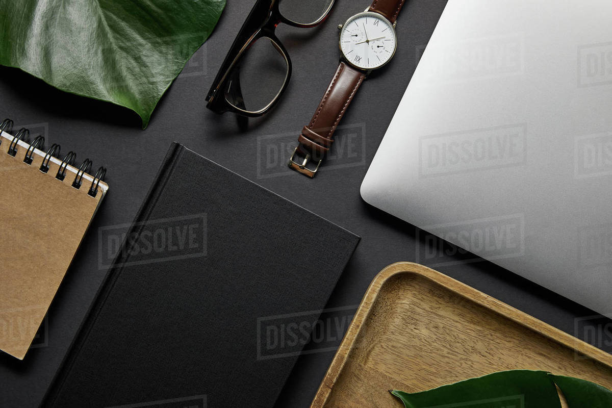 Flat lay with Notebook and laptop with glasses and watch on black ...
