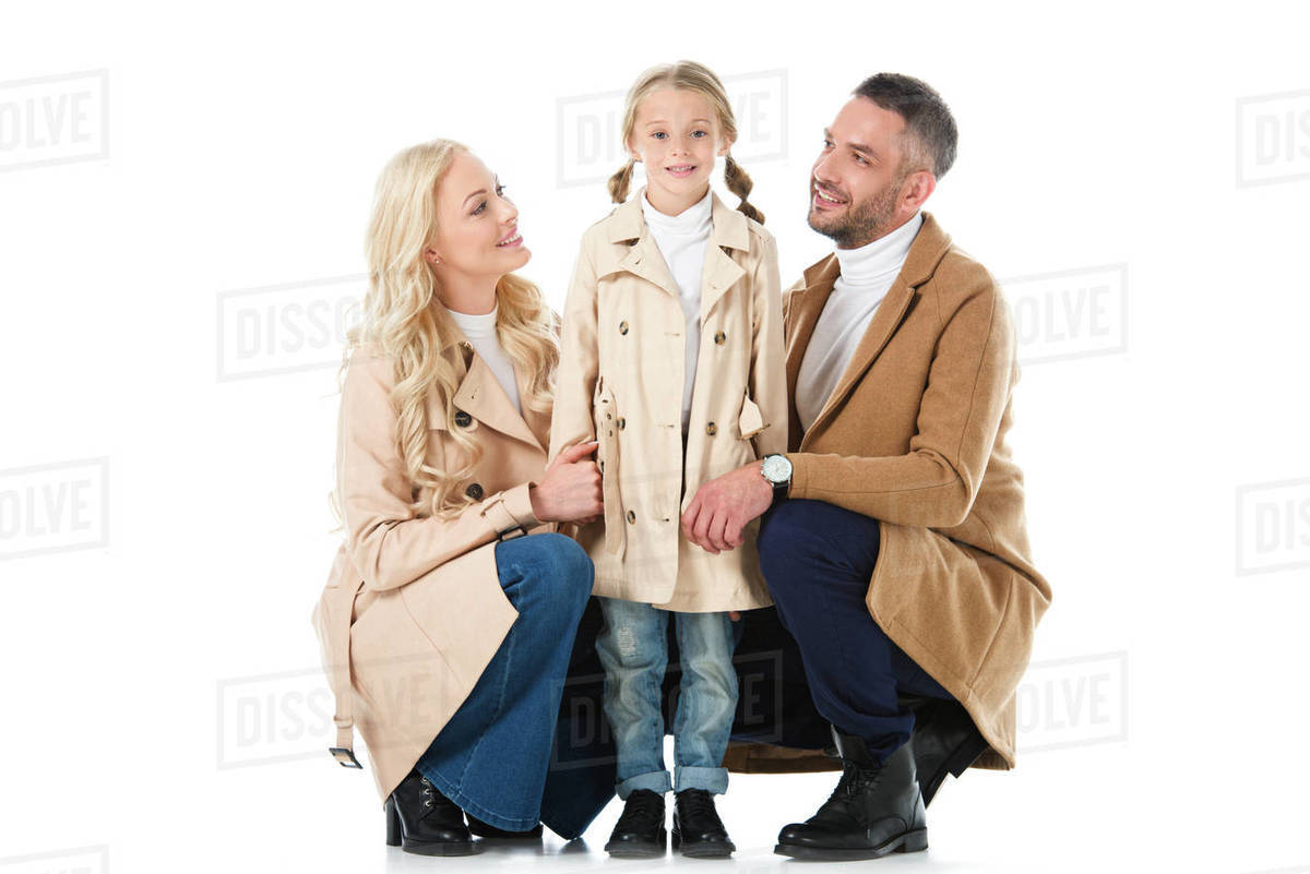 Parents with daughter in beige autumn coats, isolated on white ...