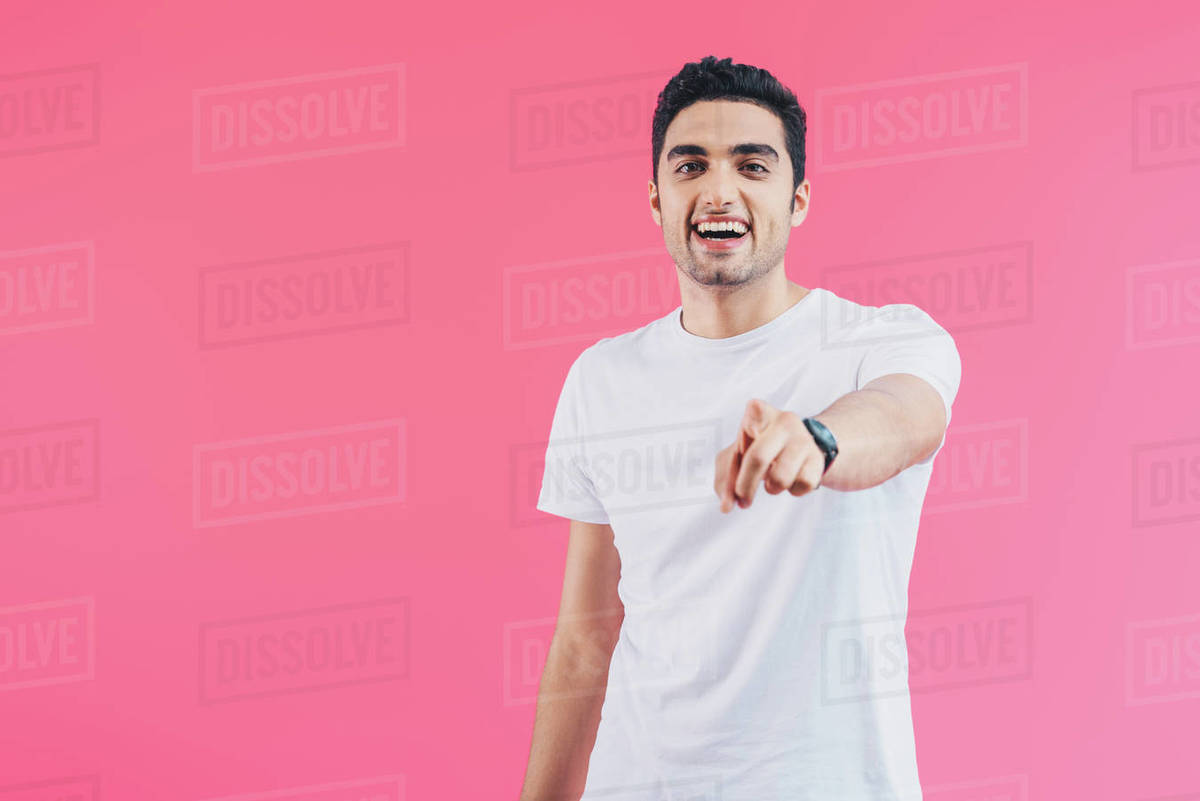 Laughing man pointing on camera isolated on pink - Stock Photo - Dissolve