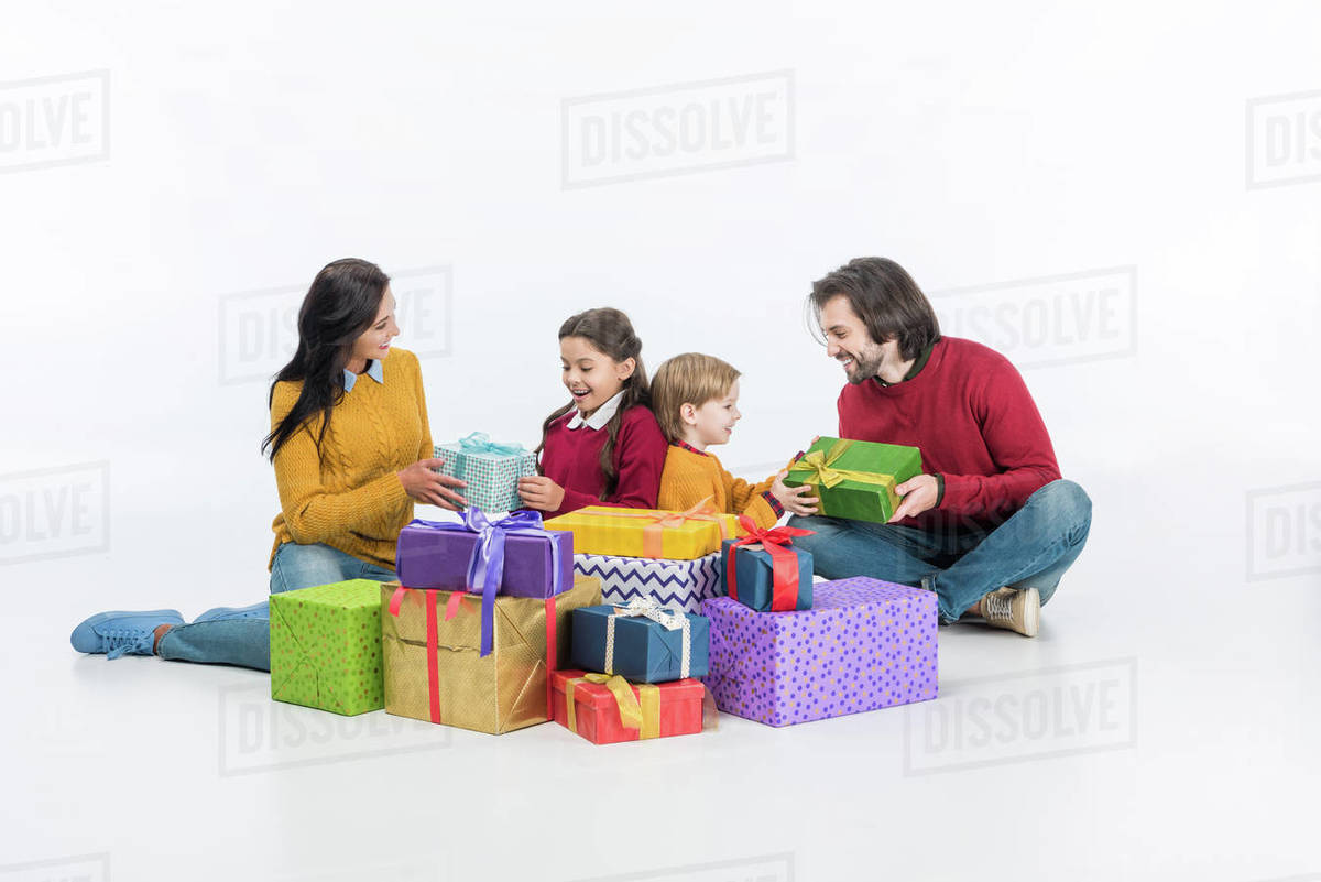 Happy parents and kids with wrapped gift boxes isolated on white ...