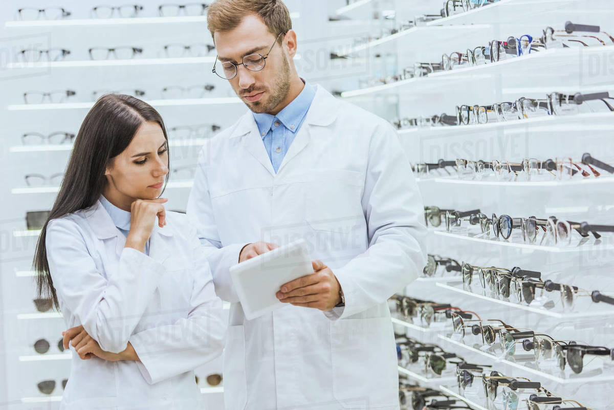 Professional optometrists working and using digital tablet in ...