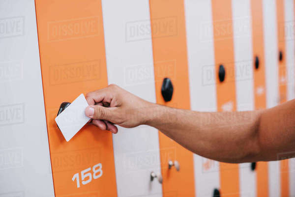 Cropped shot of sportsman magnet card to open locker at gym changing ...