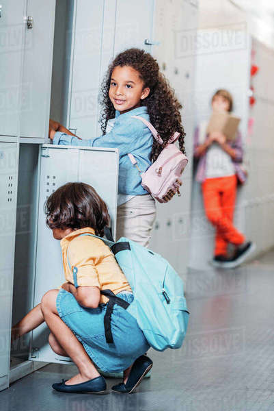 girls putting stuff in lockers at school corridor - Royalty-free Stock ...