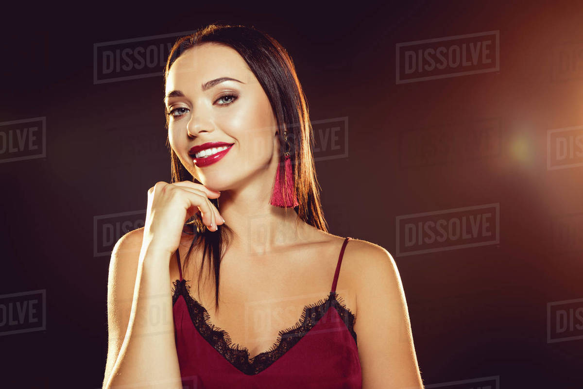 Portrait of gorgeous woman in glamour dress looking at camera on black ...