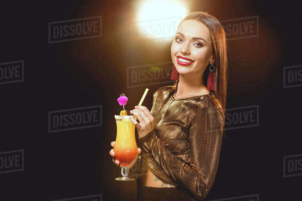 Happy glamorous girl with cocktail on black with back light - Royalty ...