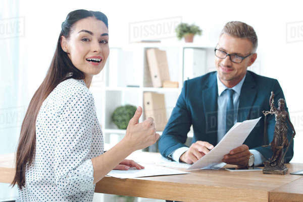Smiling lawyer holding papers and happy client showing thumb up and ...