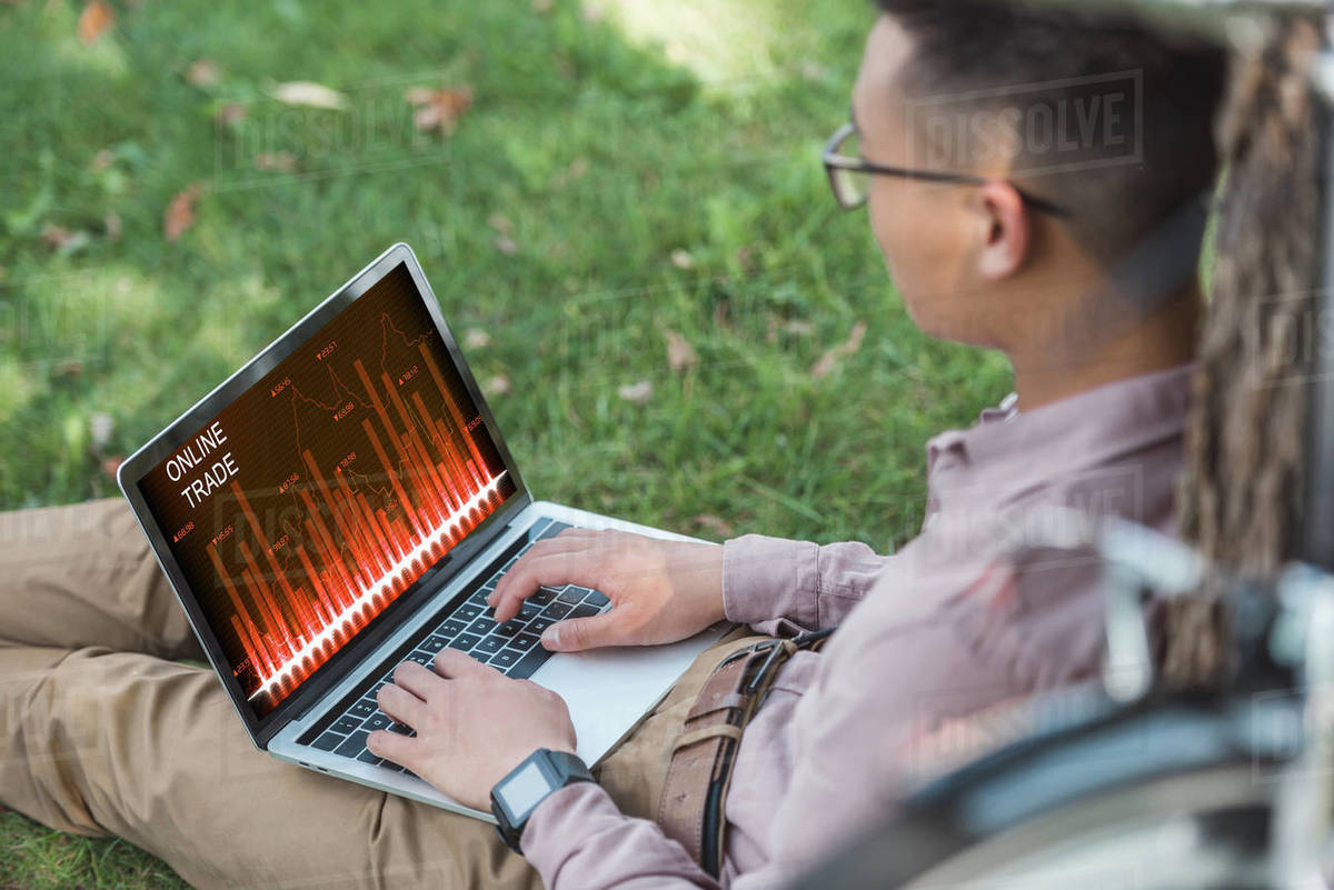 Side view of young Asian freelancer working on laptop with online trade ...