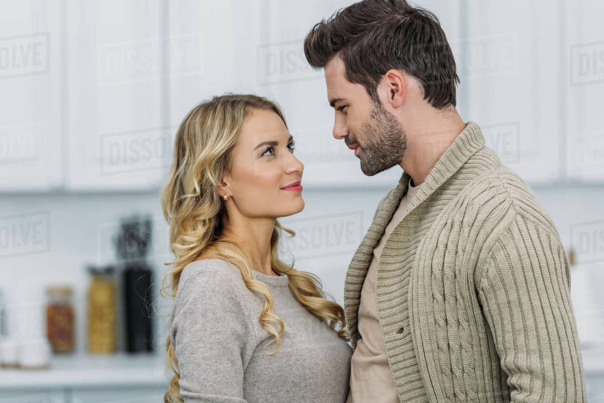 Portrait of girlfriend and boyfriend looking at each other at home ...