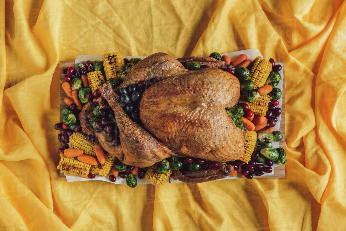 Top view of roasted festive turkey and vegetables on tabletop with ...