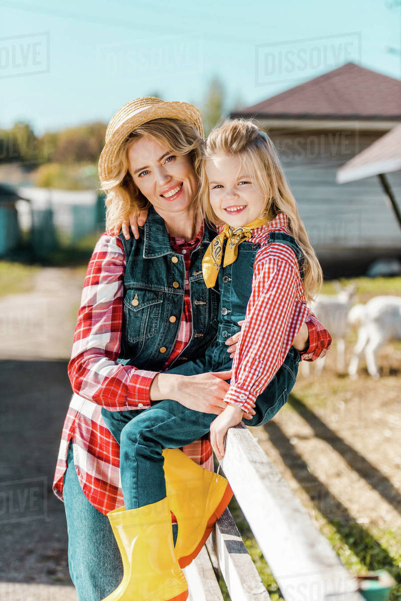 Happy adult female farmer embracing little daughter at farm - Royalty ...