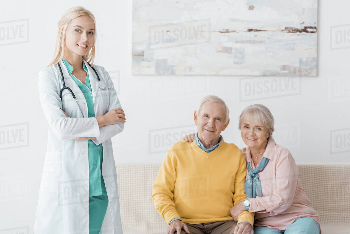 Female doctor standing near senior smiling patients in clinic - Royalty ...