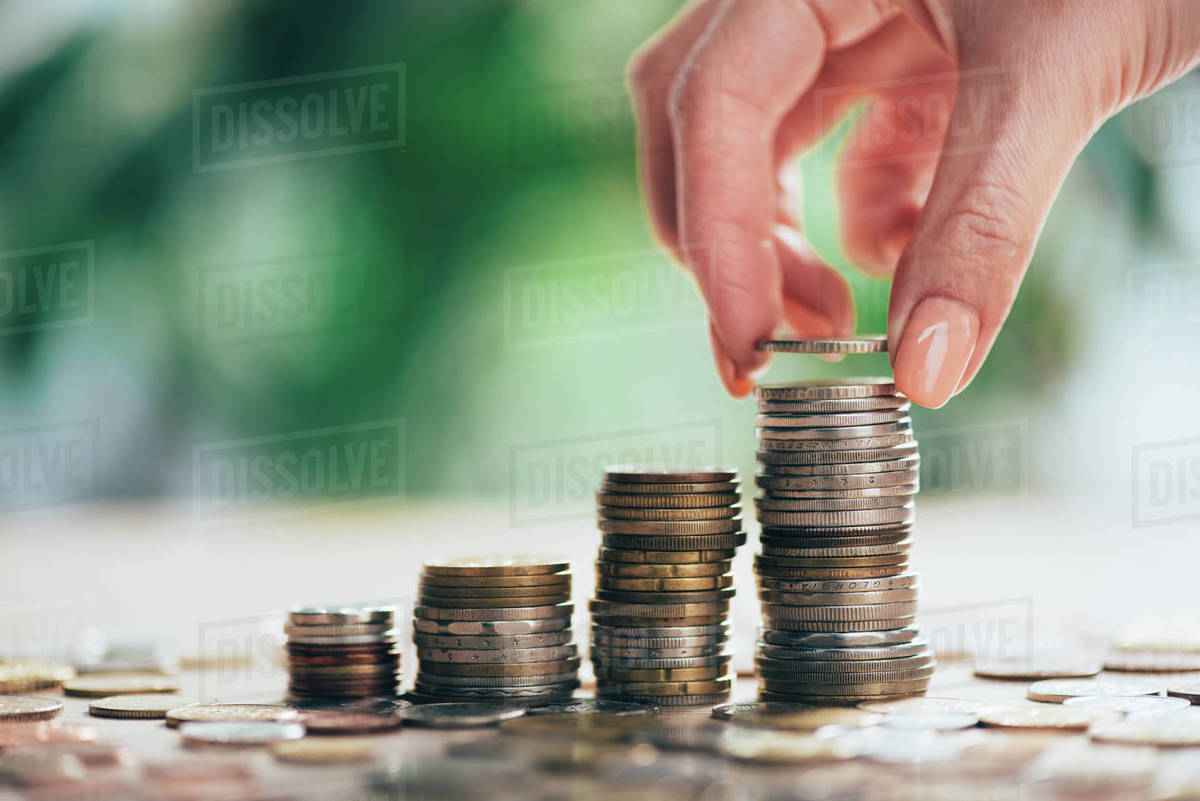 Cropped shot of person putting coin on stacked coins - Royalty-free ...