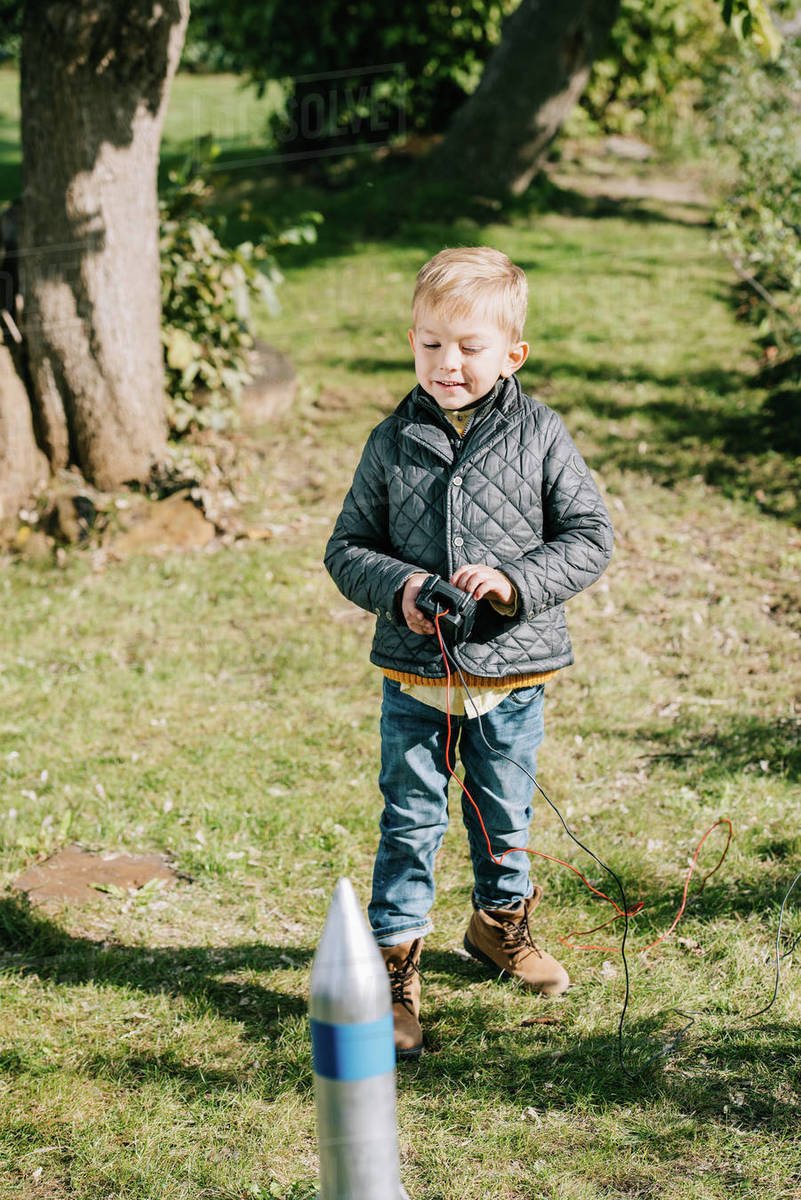 Adorable child launching model rocket outdoor - Stock Photo - Dissolve