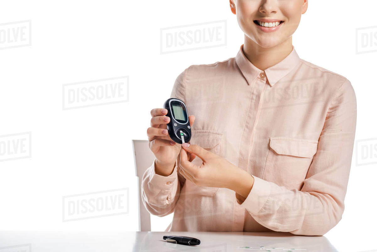 cropped image of smiling woman putting strip into glucometer isolated ...