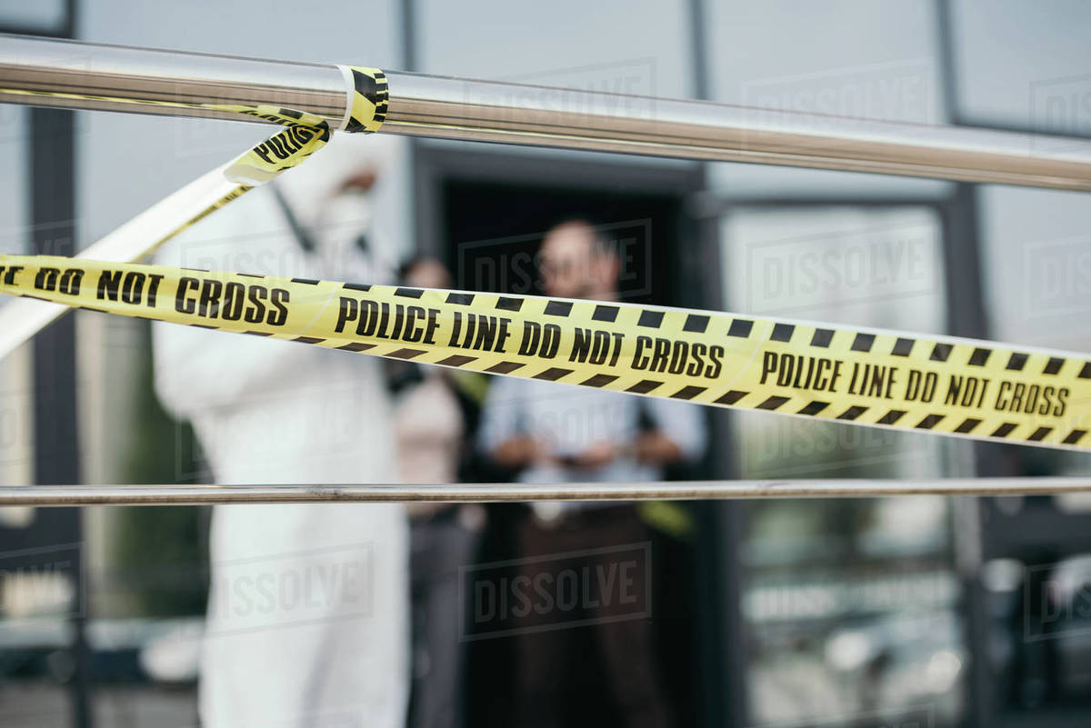 Close up view of police line with blurred detectives and criminologist ...