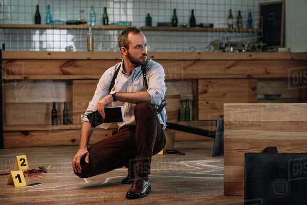 Serious male detective sitting at crime scene with notebook - Royalty ...