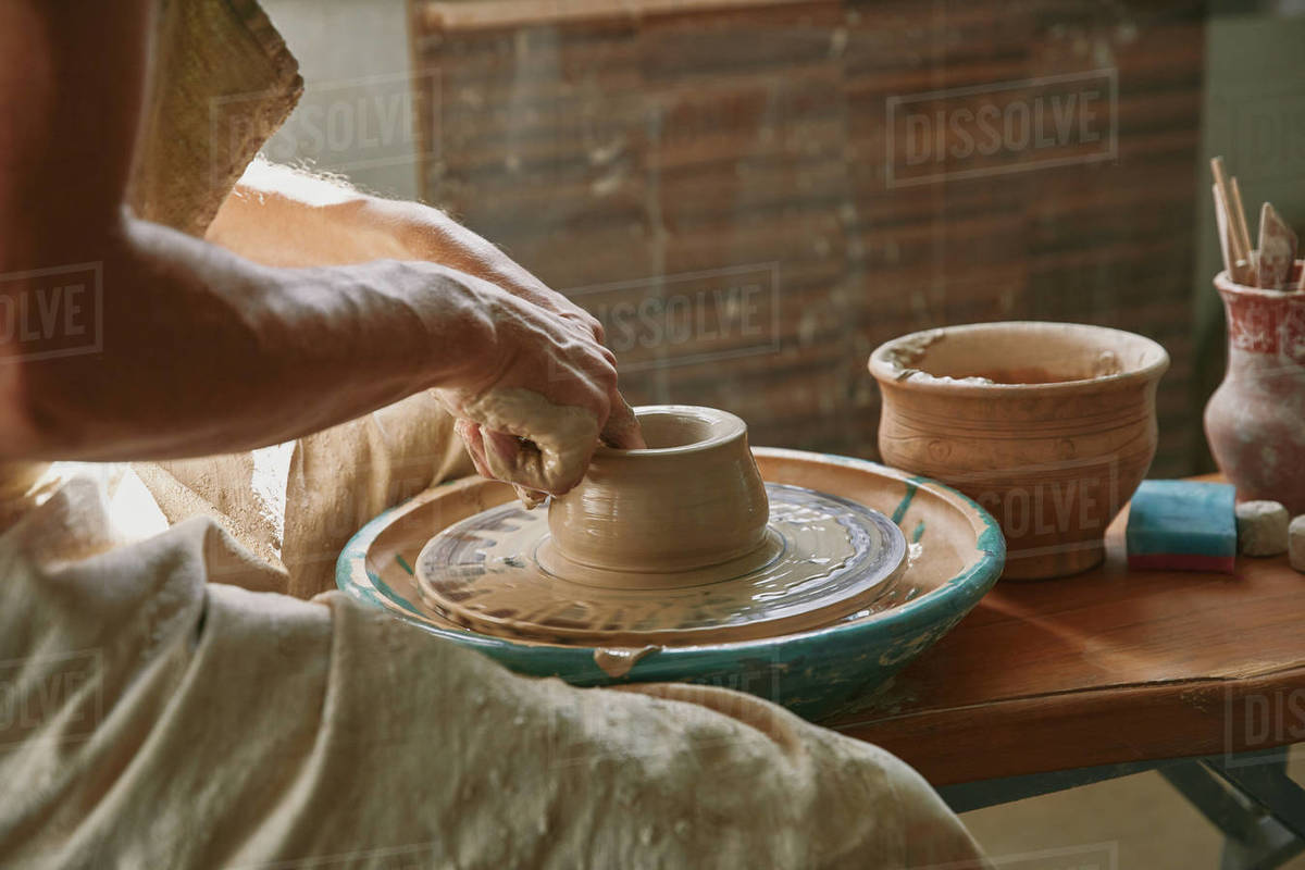 cropped image of professional potter working on pottery wheel at ...