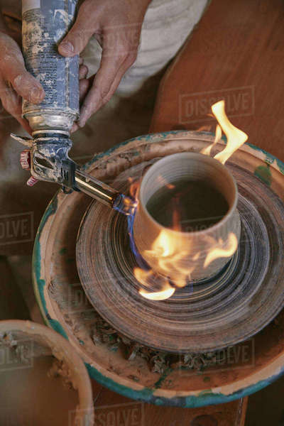 cropped image of male potter firing clay pot at pottery studio ...