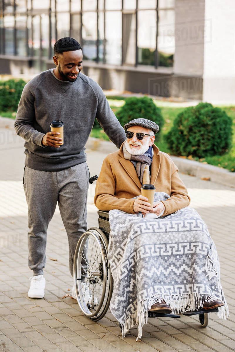 Smiling Senior Disabled Man In Wheelchair With Plaid And African